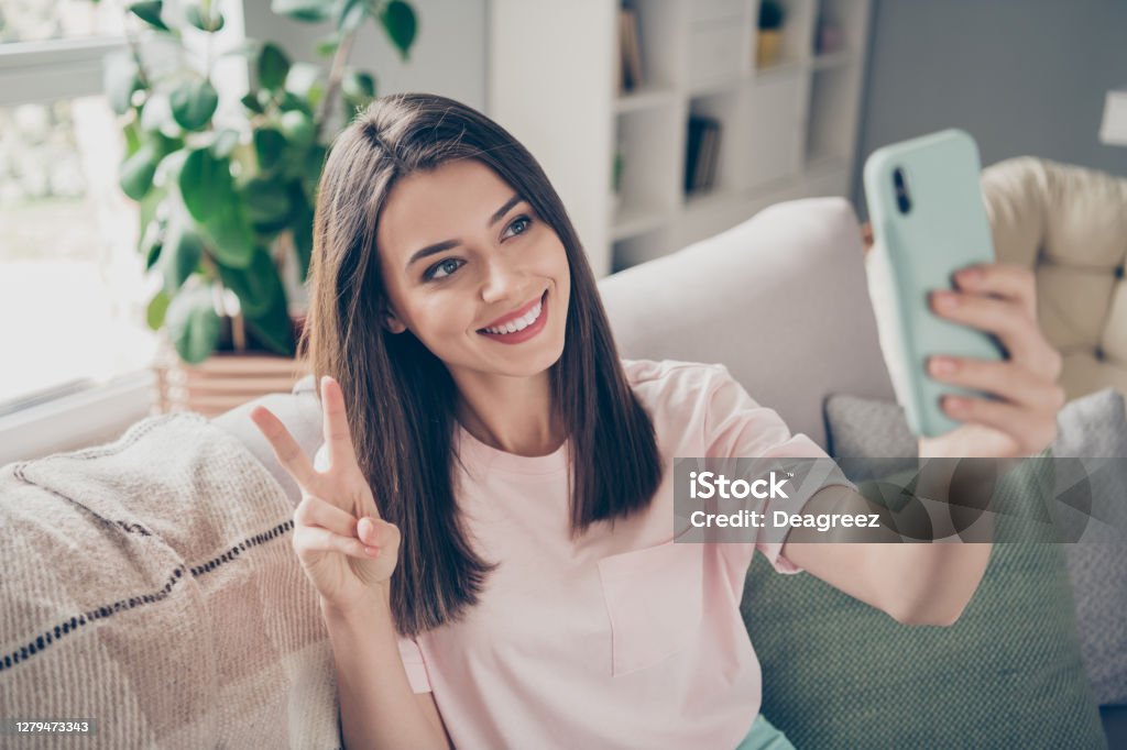 Photo Of Homey Lady Hold Telephone Make Selfies Show Vsign Symbol Sit