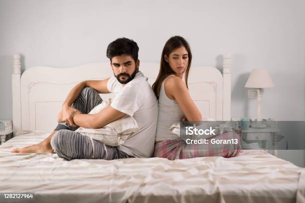 Displeased Couple Ignoring Each Other While Sitting Back To Back On A