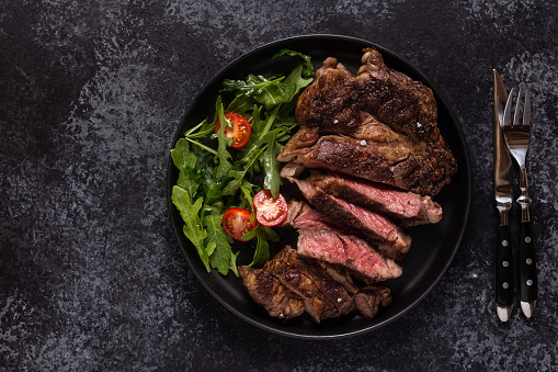 Steak Daging Sapi Panggang Dengan Rempahrempah Di Piring Hitam Foto