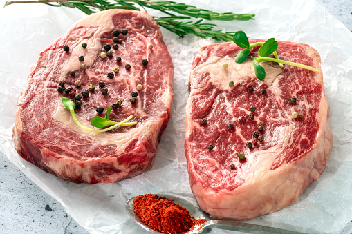 Dua Daging Sapi Marmer Mentah Steak Ribeye Dengan Rempahrempah Di Atas