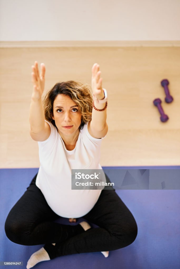 Middleaged Pregnant Woman Sitting In Lotus Yoga Position And Meditating