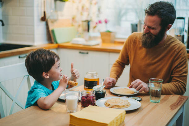 Free Stock Photo of Father feeding young son at breakfast table ...