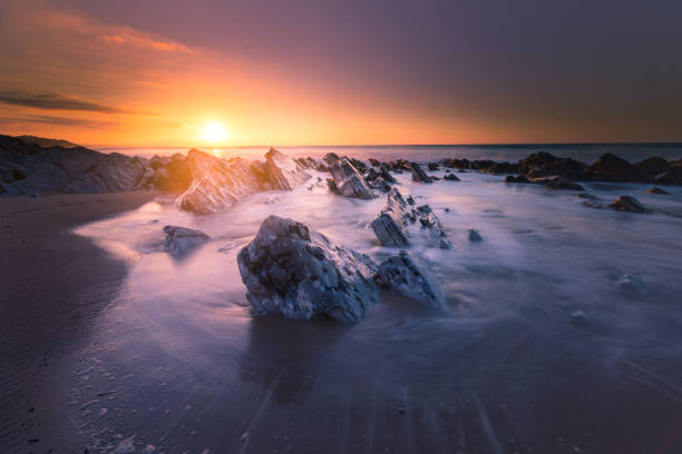 Free Stock Photo of Sunset over soft waves and boulder formation ...