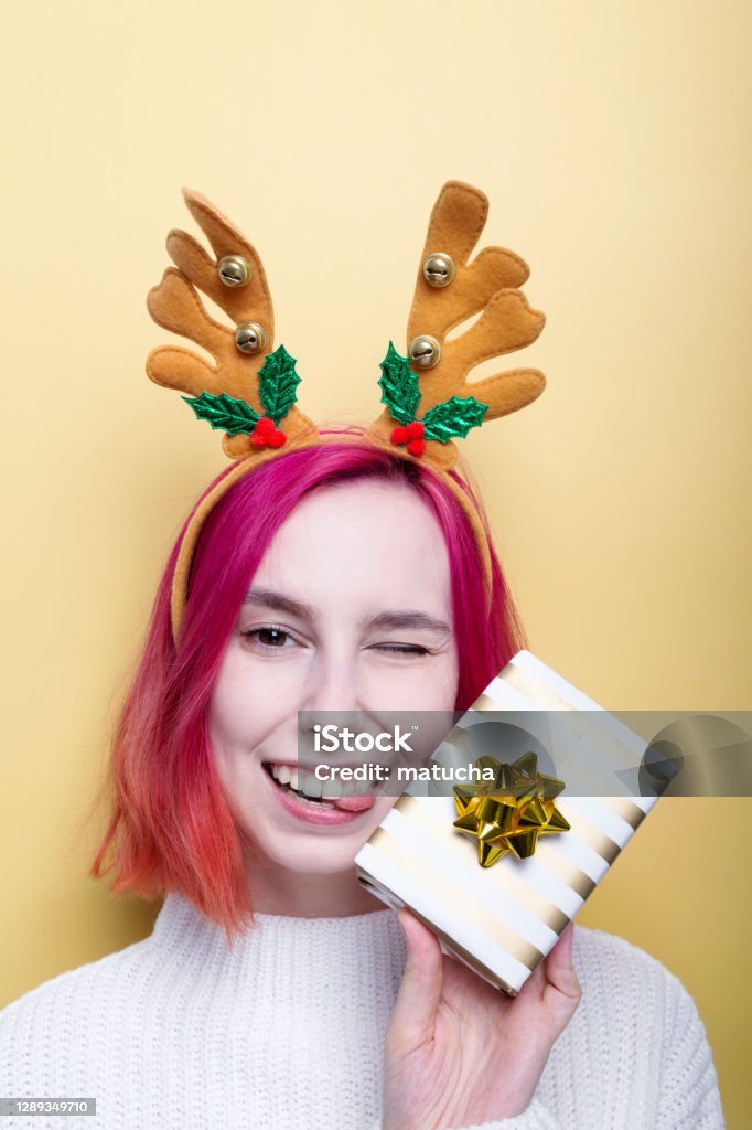 Girl In White Sweater And Deer Horns On Head Makes Funny Face Sticks