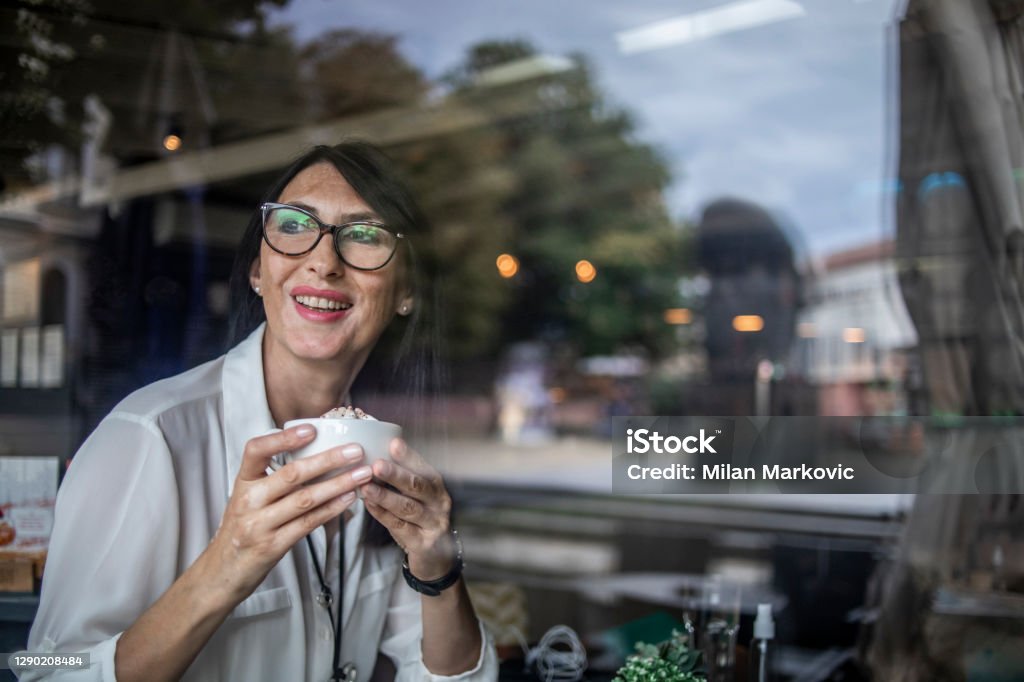 One Woman A Modern Mature Lady With Black Hair Is Drinking Coffee In A