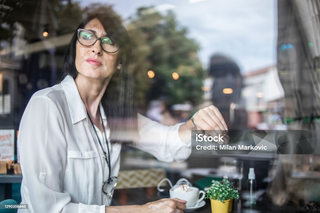 One Woman A Modern Mature Lady With Black Hair Is Drinking Coffee In A