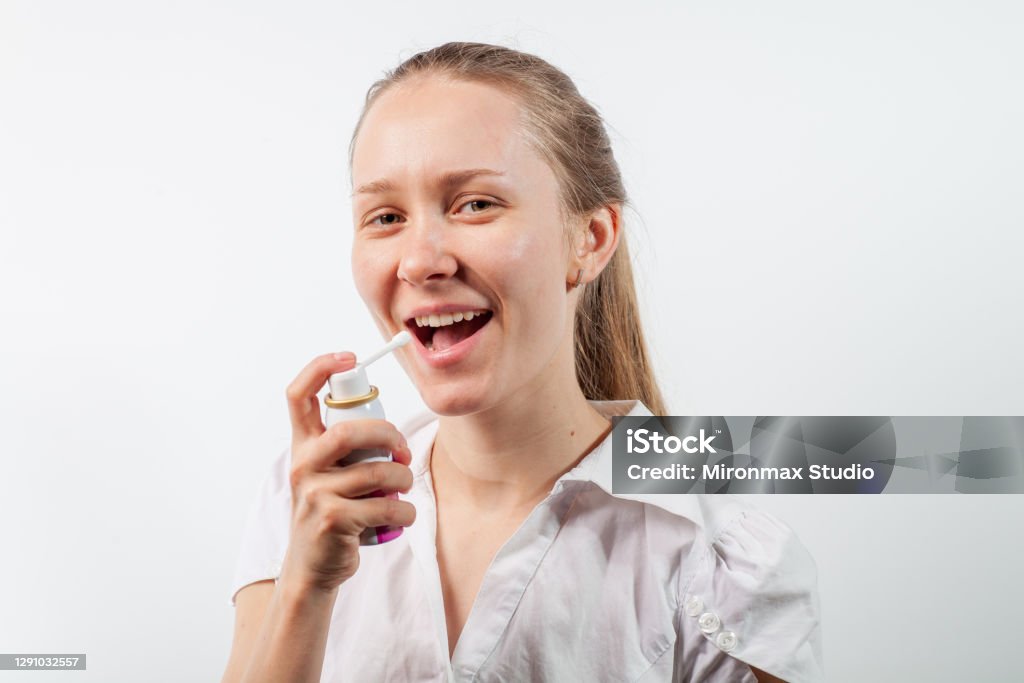 Young And Attractive Doctor With A Throat Spray Isolated On White Stock