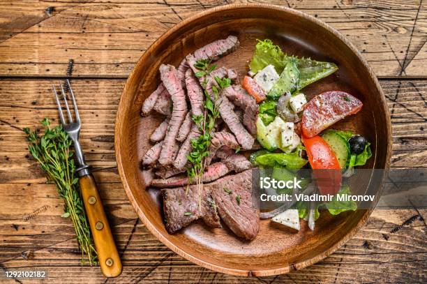 Barbekyu Daging Sapi Potong Steak Pantat Di Piring Kayu Dengan Salad