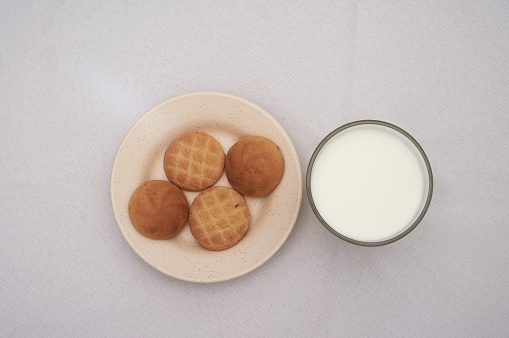Segelas Susu Dan Sepiring Kue Di Atas Meja Dengan Taplak Meja Putih