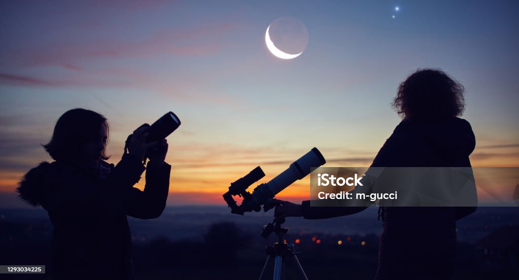 Mother And Daughter Observing Stars Planets Moon And Night Sky With