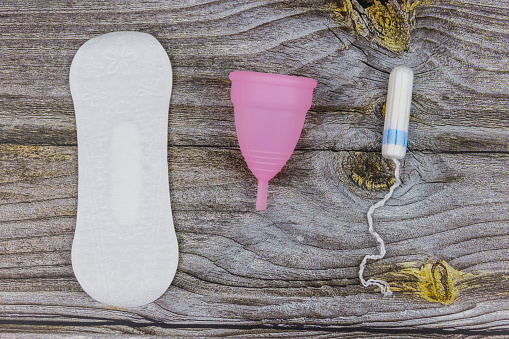 Pembalut Wanita Tampon Dan Cangkir Menstruasi Di Latar Belakang Kayu ... Pembalut Wanita Tampon Dan Cangkir Menstruasi Di Latar Belakang Kayu ...