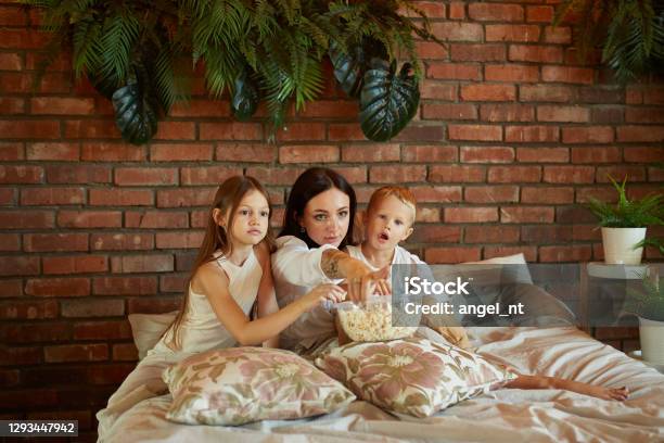 Photo Libre De Droit De Maman Sassoit Sur Le Lit Avec Son Fils Et Sa Fille Et Regarde Un Film