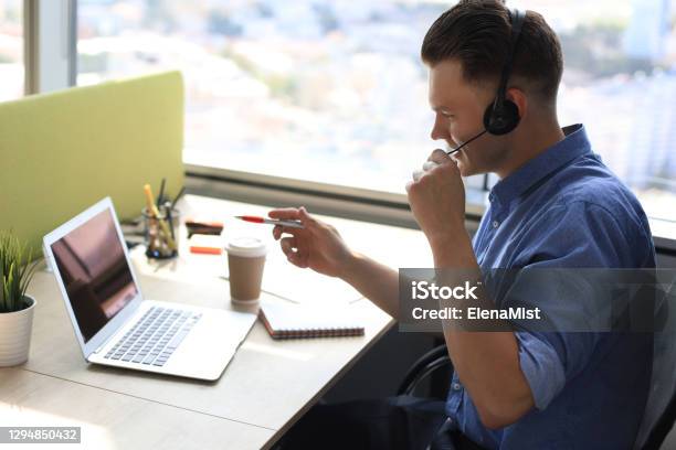 Operator Pria Telepon Dukungan Muda Yang Ceria Di Headset Di Tempat ... Operator Pria Telepon Dukungan Muda Yang Ceria Di Headset Di Tempat ...