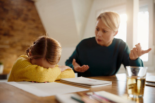 Niña Pequeña Siendo Regañada Por Su Madre Durante La Educación En Casa Foto De Stock Y Más Banco