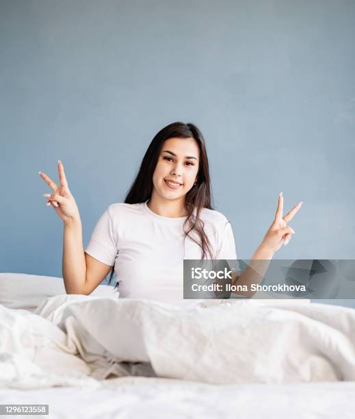Wanita Berambut Cokelat Muda Yang Cantik Duduk Terjaga Di Tempat Tidur