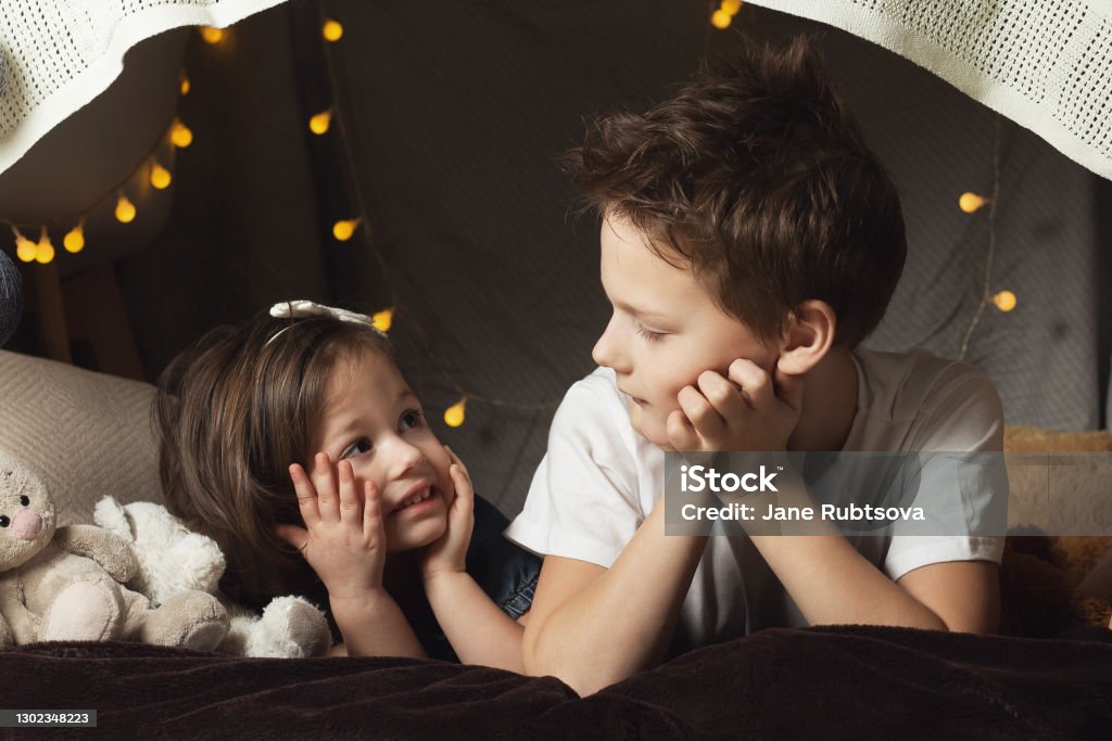 Siblings Lie In A Hut Of Chairs And Blankets Brother And Sister Smiling