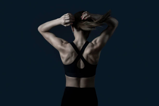 Free Stock Photo of Woman in Black Sports Bra Top Examining Her Back ...