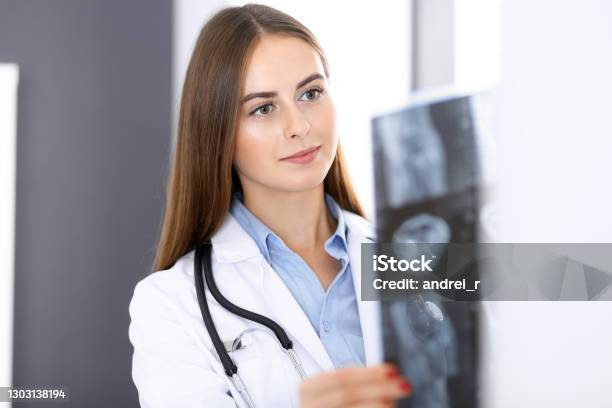 Wanita Dokter Memeriksa Gambar Xray Sambil Berdiri Di Dekat Jendela Di