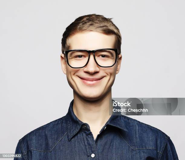 Portrait Of A Smart Young Man Wearing Eyeglasses Standing Against White