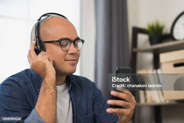 Pria Muda Asia Mengenakan Headphone Dan Mendengarkan Musik Dari ... Pria Muda Asia Mengenakan Headphone Dan Mendengarkan Musik Dari ...