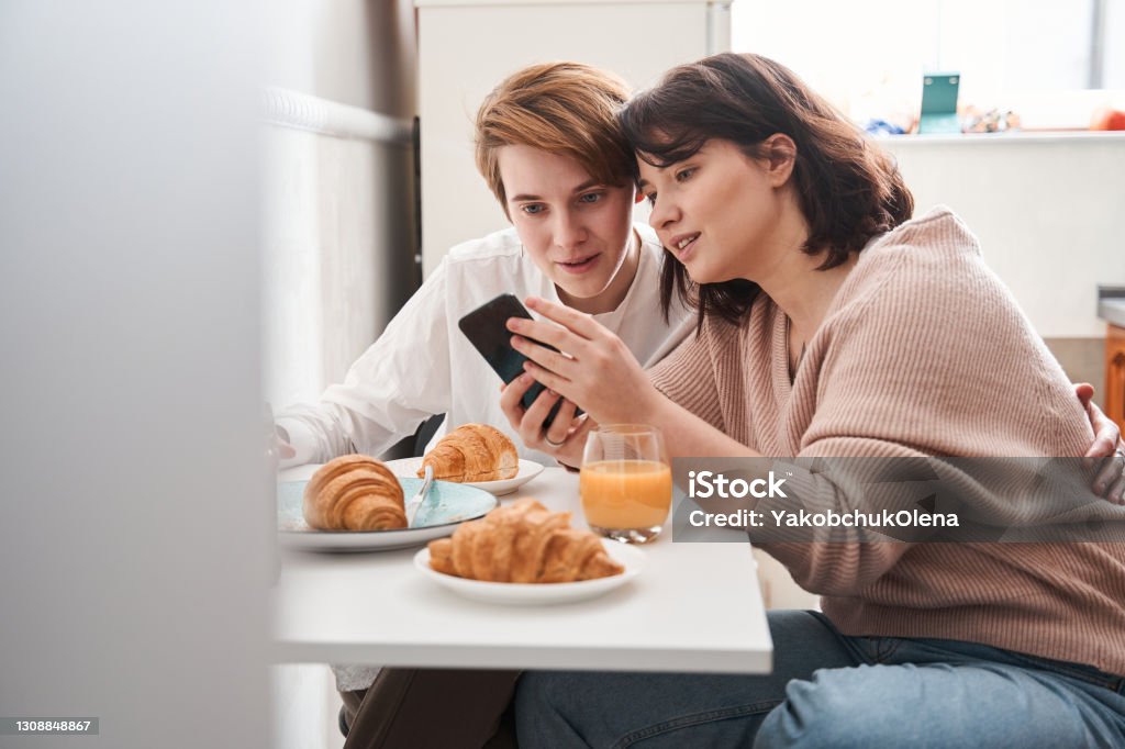 Woman Showing Something On Her Smartphone To Her Short Haired