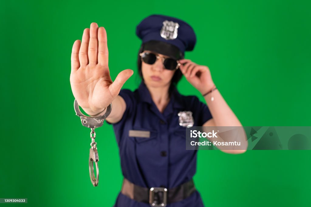 Female Police Officer Makes A Stop Gesture With Her Hand With Handcuff