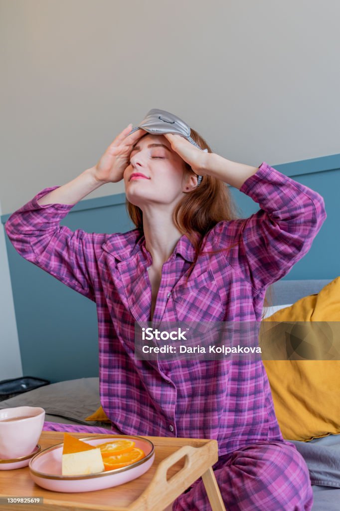 Young Woman Takes Off His Sleep Mask And Prepares For Breakfast Sitting