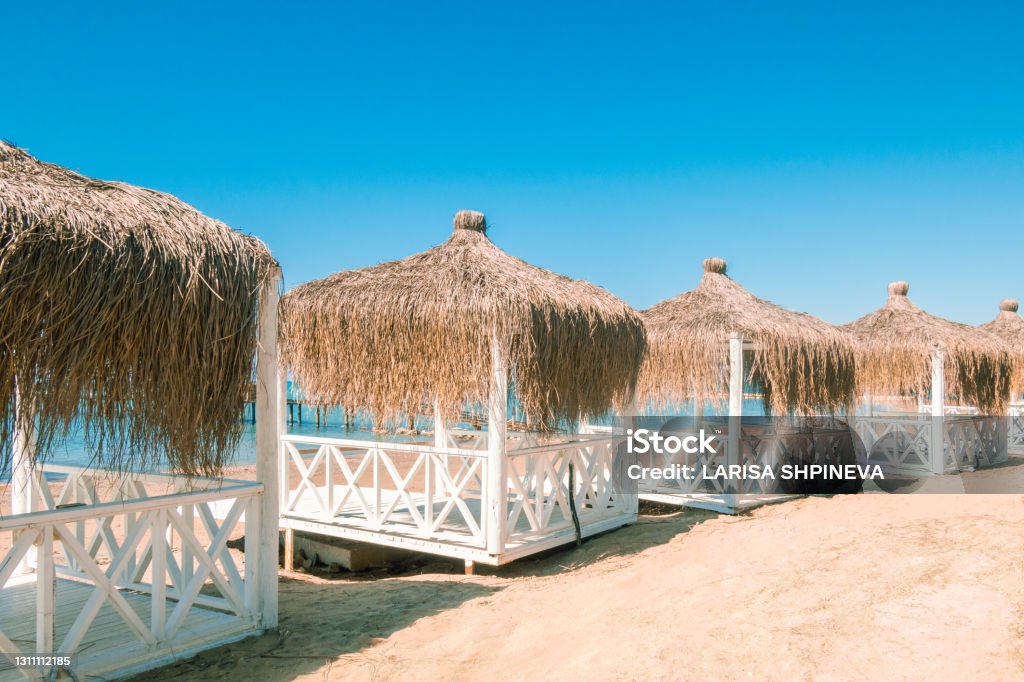 Massage Huts With Thatched Roof On Sand Beach Along Seaside Luxury