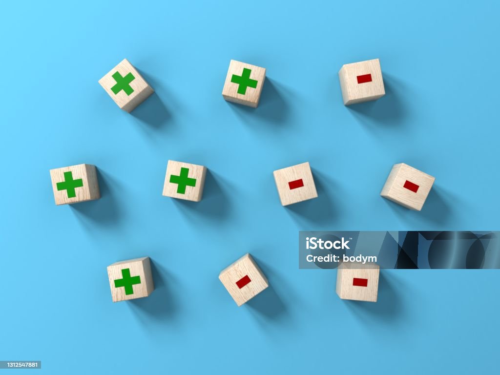 Wood Blocks With Plus And Minus On Blue Background Stock Photo
