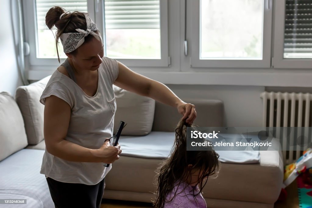 Mother Cutting Five Years Old Daughters Hair At Home During Lockdown