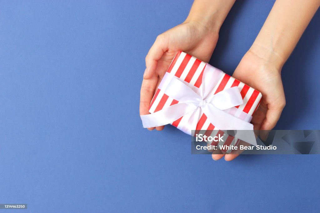 Hadiah Di Tangan Wanita Pada Tampilan Atas Latar Belakang Berwarna Foto ... Hadiah Di Tangan Wanita Pada Tampilan Atas Latar Belakang Berwarna Foto ...