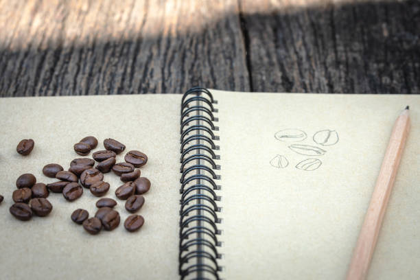 Free Stock Photo of A pile of coffee beans and a spiral notebook ...