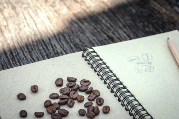Free Stock Photo of A notebook and coffee beans and a pencil on a wood ...