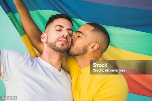 Gay Couple Embracing And Showing Their Love With Rainbow Flag Stock