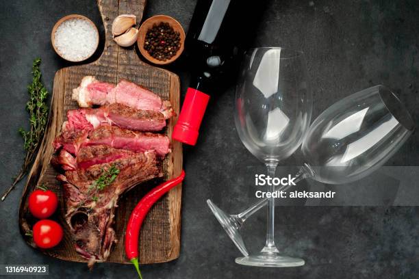 Steak Daging Sapi Panggang Dan Botol Anggur Dengan Kacamata Di Latar