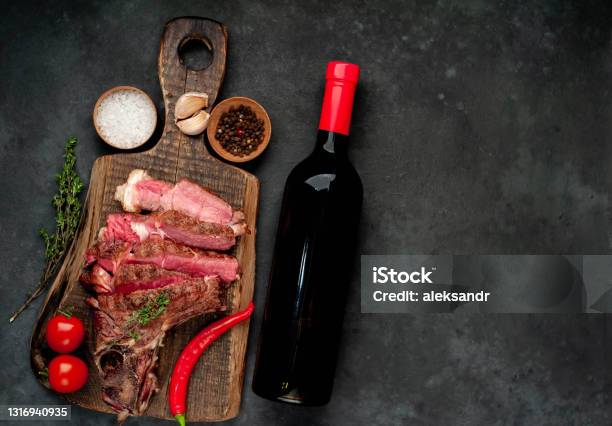 Steak Daging Sapi Panggang Dan Botol Anggur Dengan Kacamata Di Latar