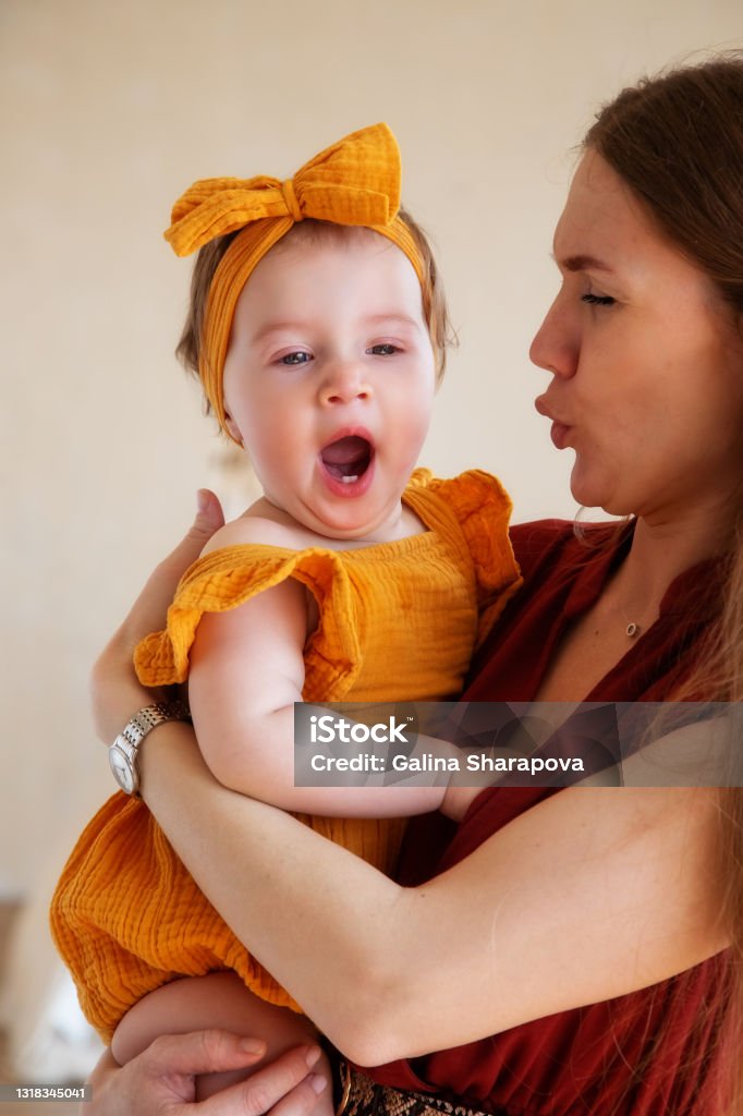 Oneyearold Daughter In Yellow Clothes Yawns In The Arms Of A Loving