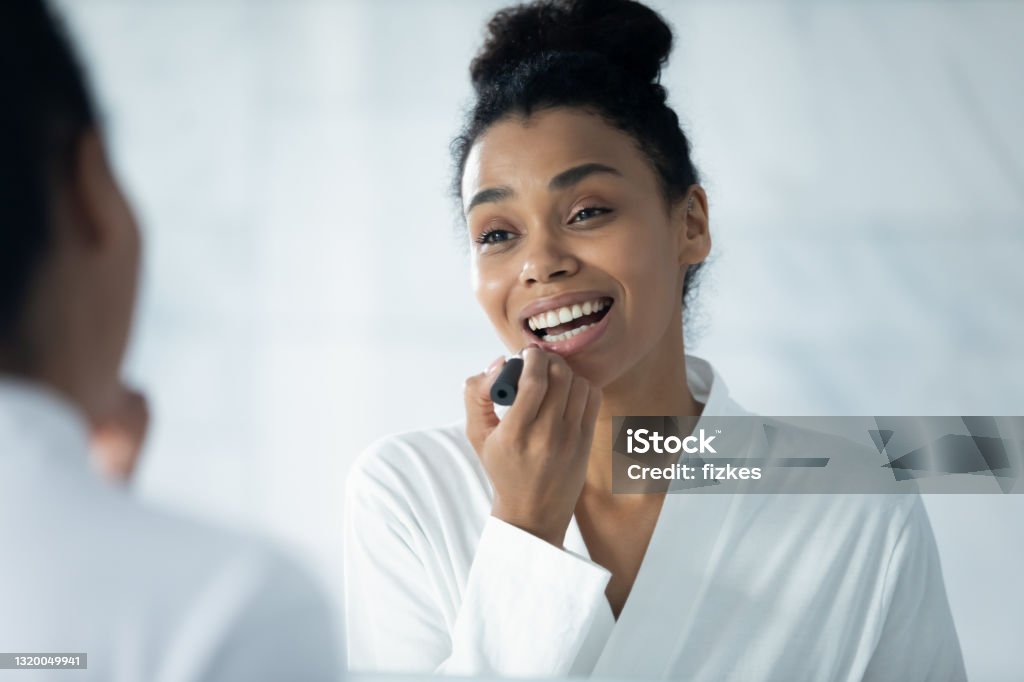 Happy Beautiful Millennial Black Girl Putting On Lipstick Rouging Lips