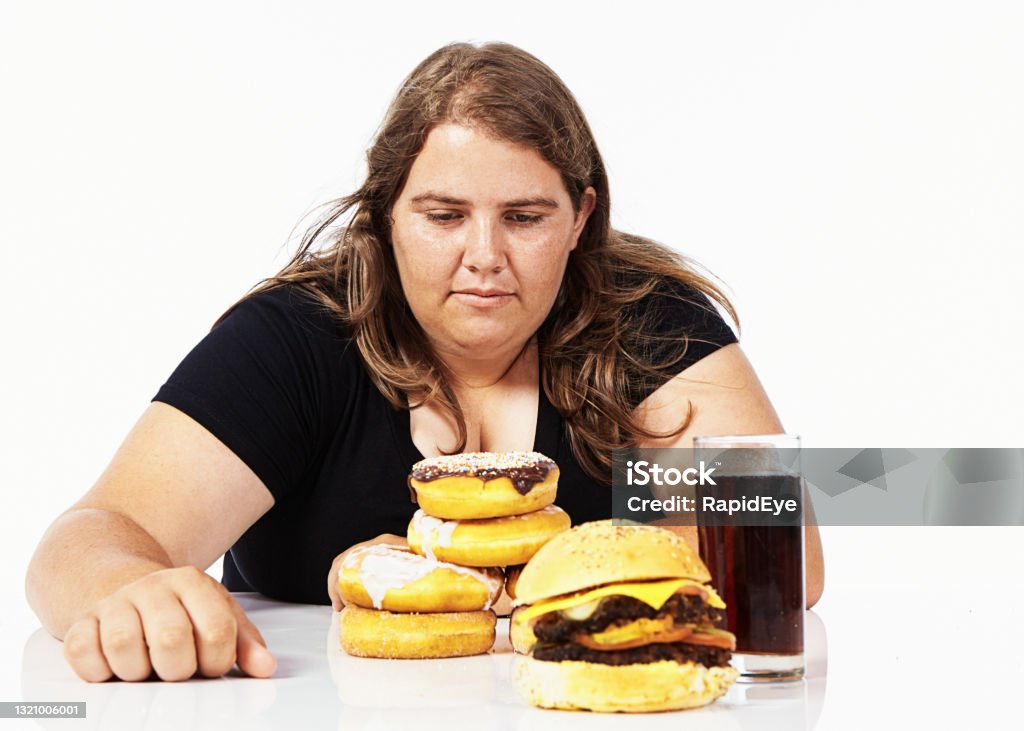 Photo Libre De Droit De Une Jeune Femme A Lair Glouton Alors Quelle Sassoit Avec Des Beignets Du
