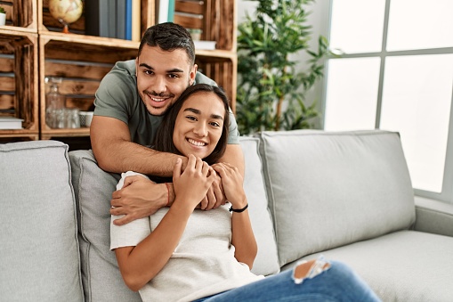 Photo Libre De Droit De Jeune Couple Latin Assis Sur Le Canapé En