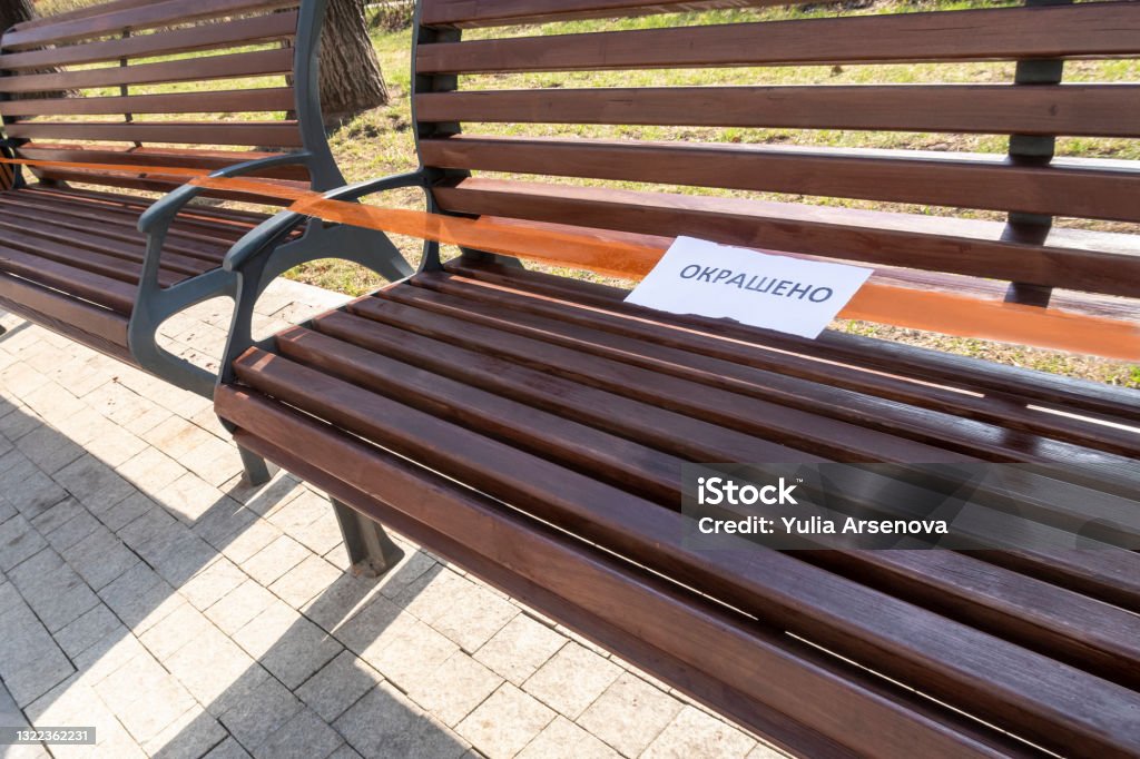 Målade Bara Parkbänkar Med Varning Orange Band Och Skylt Med Rysk Text ... Målade Bara Parkbänkar Med Varning Orange Band Och Skylt Med Rysk Text ...