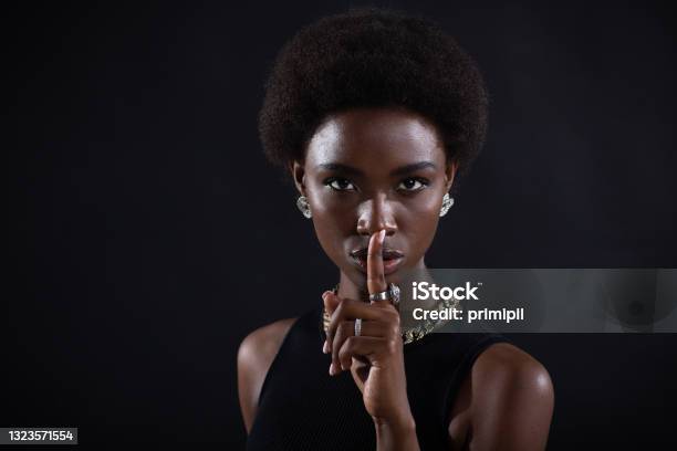 Closeup Of Beautiful Young Darkskinned Woman With Finger On Her Lips