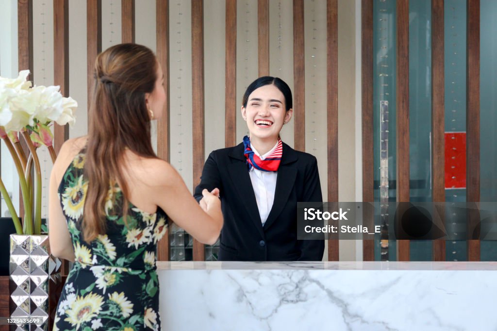 Happy Smiling Young Beautiful Asian Female Receptionist In Suit Shaking