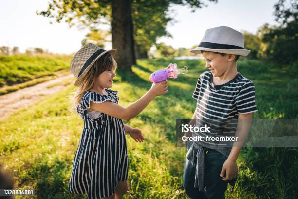 Little Brother And Sister Playing With Bubble Wand In Nature Stock