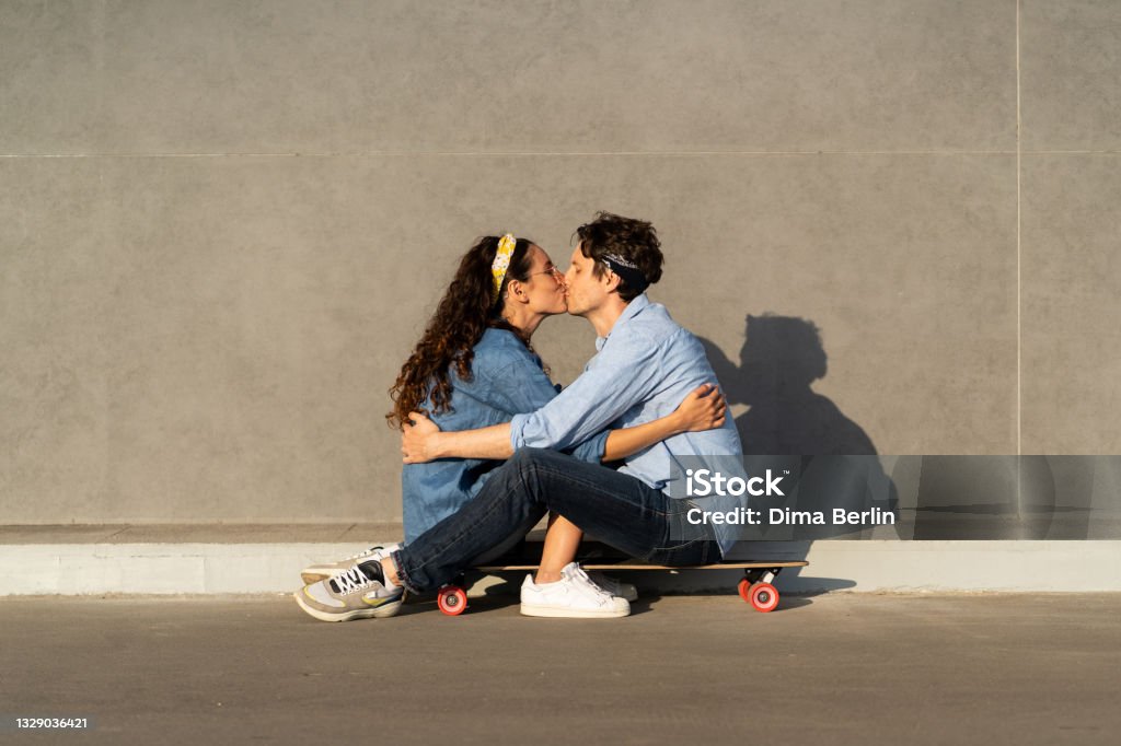 Photo Libre De Droit De Jeune Couple Aimant Assis Sur Un Longboard En
