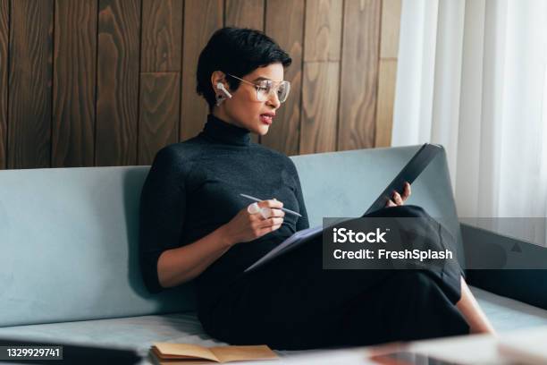 Wanita Muda Cantik Yang Duduk Di Sofa Di Kantornya Memeriksa Laporan