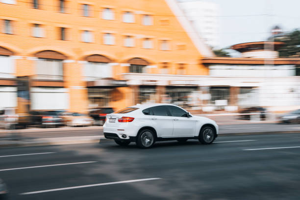 Free Stock Photo of White Car Driving Down Street Next to Tall ...