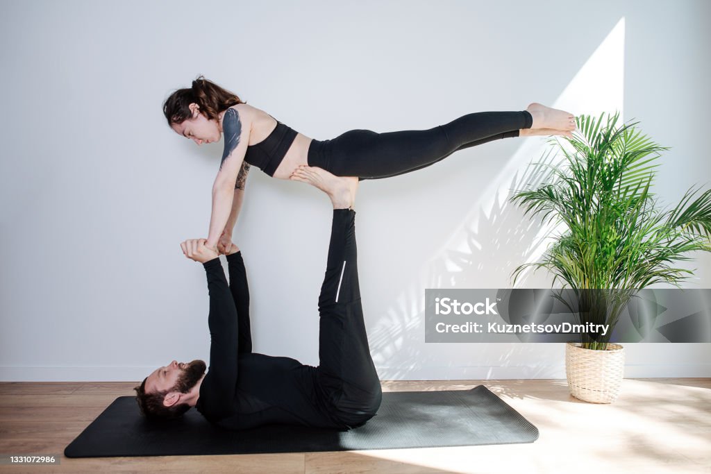 Man And Woman Doing Gymnastic Form He Is Holding Her On Strtaight Arms