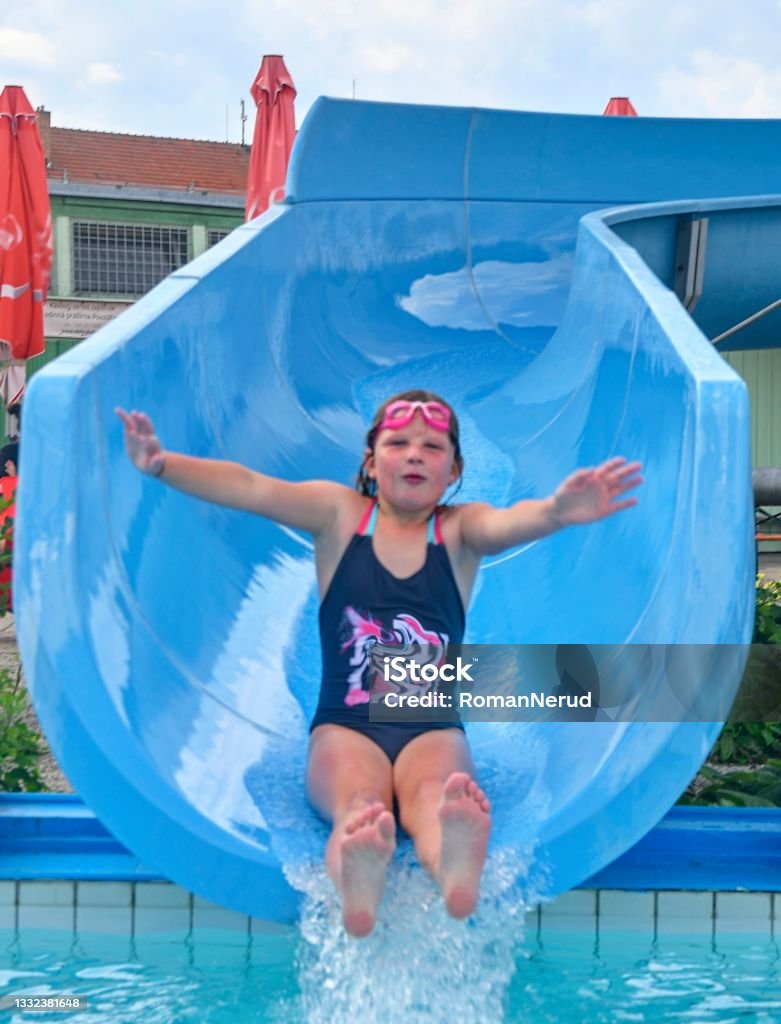 Girl Sliding Down On A Water Slide Into Plunge Pool In Aqua Park