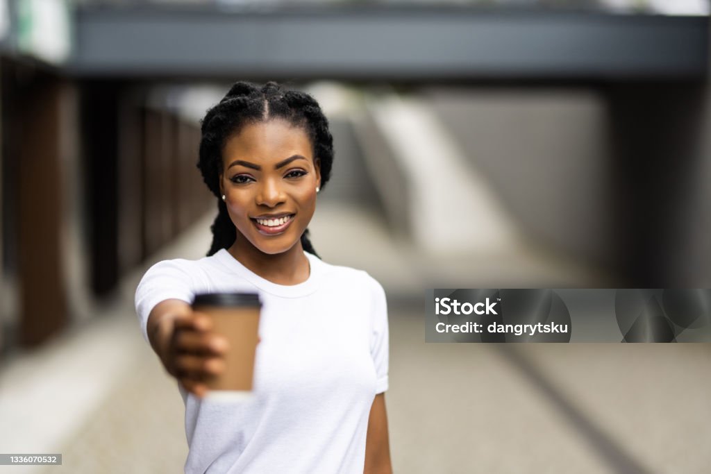 Cheerful Young African Woman Walking Outdoors Holding Takeaway Coffee